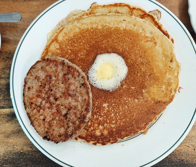 A golden pancake with melting butter and a sausage patty&mdash;breakfast simplicity that somehow tastes better in a small-town Ohio diner than anywhere else.