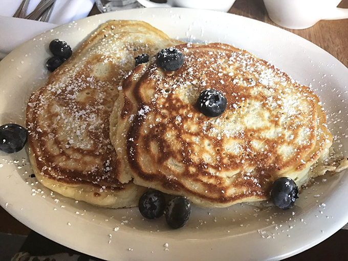 Golden pancakes dusted with powdered sugar and dotted with blueberries &ndash; proof that simplicity, when executed perfectly, needs no elaborate explanation.