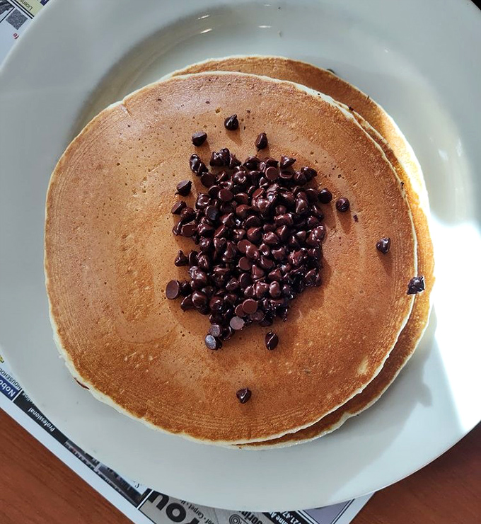 Chocolate chip pancakes that prove sometimes the simplest pleasures are the most profound. That perfect golden-brown canvas says it all.