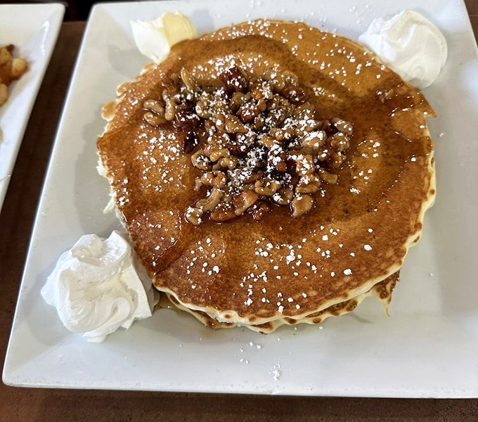 This isn't just a pancake—it's a fluffy canvas for walnut artistry, where powdered sugar falls like the gentlest Pennsylvania snowflake.