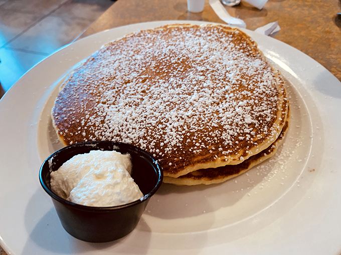 Pancakes dusted with powdered sugar and served with a side of whipped cream &ndash; breakfast's way of saying "you deserve this."