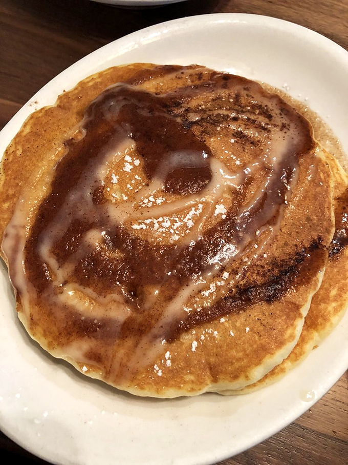The cinnamon swirl pancake doesn't just arrive at your table &ndash; it makes an entrance, trailing its aromatic cinnamon-sugar perfume like a breakfast celebrity. 
