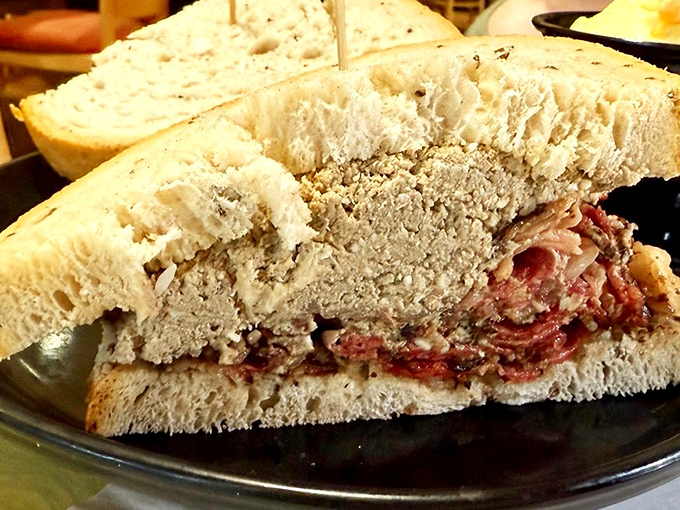 This isn't just a sandwich; it's an architectural marvel of pastrami and rye that requires both hands, several napkins, and absolutely zero shame.