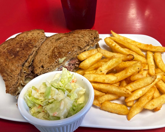 This isn't just a sandwich, it's edible nostalgia &ndash; a perfectly grilled patty melt with crispy fries and coleslaw that would make your grandmother proud.