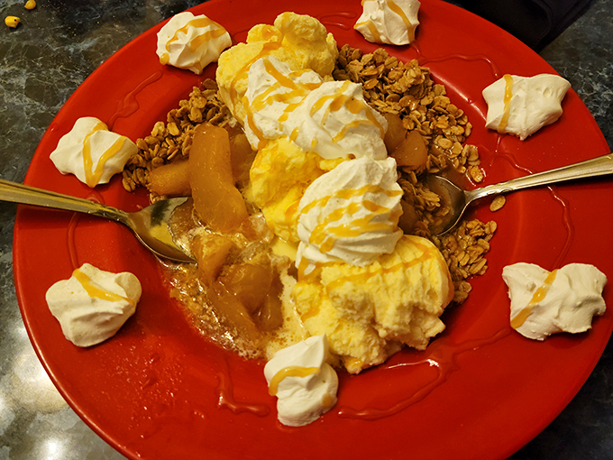 Not just dessert, but a warm hug in a bowl&mdash;peach cobbler crowned with vanilla ice cream, whipped cream, and a sprinkle of granola for that perfect textural contrast.