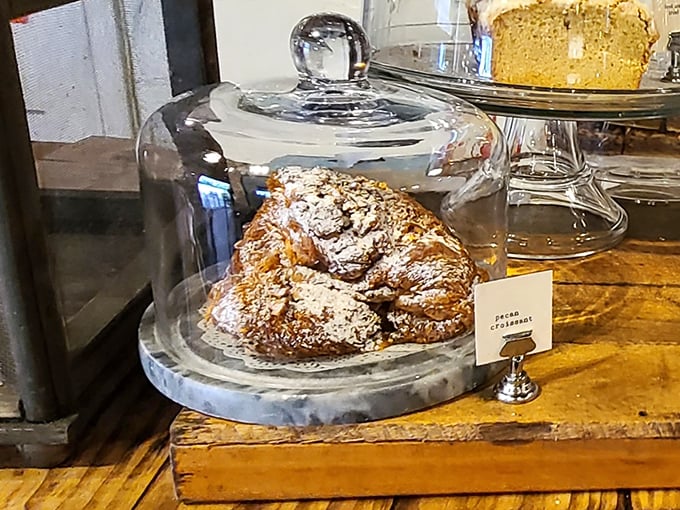This pecan croissant under glass isn't just pastry – it's edible architecture, with layers that would make Frank Lloyd Wright weep with buttery joy.