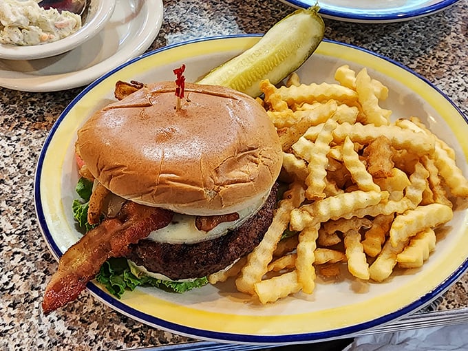This isn't just a burger; it's an architectural masterpiece of beef, bacon, and melty cheese on a perfectly toasted bun, escorted by a regiment of crispy crinkle-cut fries.