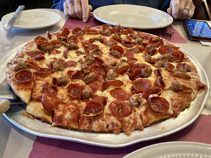 Pizza perfection doesn't need fancy toppings &ndash; just perfectly balanced pepperoni, sausage, and cheese on a crust that's been refined over decades.