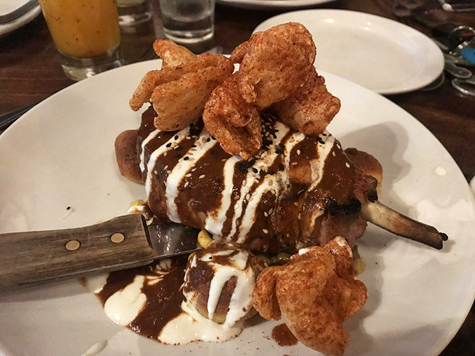 This isn't just dinner, it's edible architecture. Crispy chicharrones crown a dish that makes ordinary pork chops seem like a sad mistake.