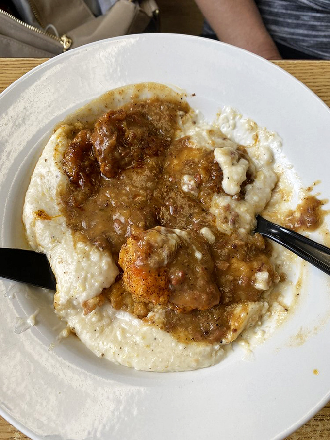 Creamy grits cradle perfectly cooked pork cutlet in a savory sauce. This isn't just pork cutlet; it's the dish that makes Yankees finally understand what the fuss is about.