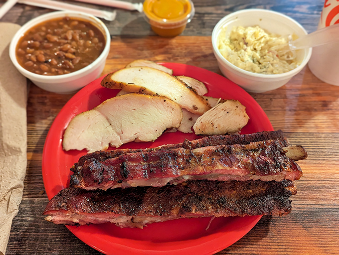 A plate that tells the whole story: perfectly smoked ribs with that signature bark, tender chicken, and sides that refuse to be afterthoughts.