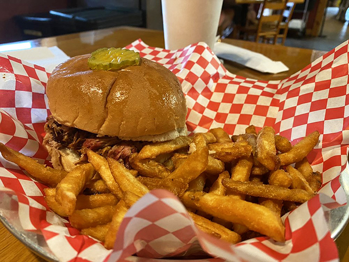 A pulled pork sandwich that doesn't need fancy garnishes to impress. Just honest barbecue on a bun with fries standing guard.