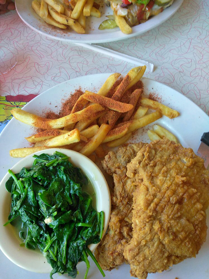 Soul food meets art form: crispy pork chop alongside vibrant greens. The kind of plate that makes you want to high-five the chef.
