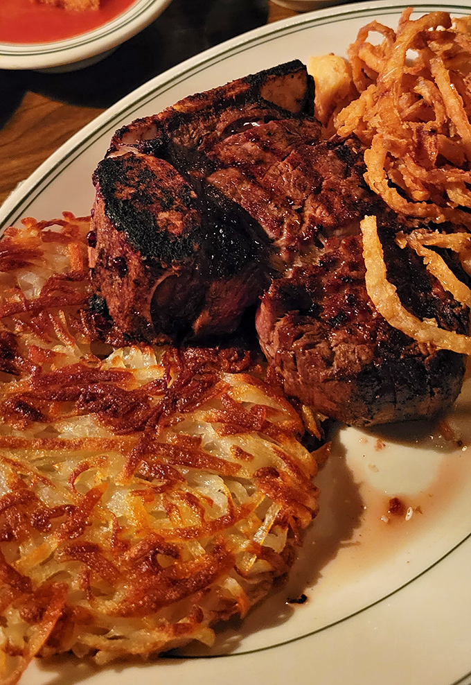 The porterhouse arrives like a challenge &ndash; gloriously charred exterior, tender interior, and those crispy hash browns that might steal the show.