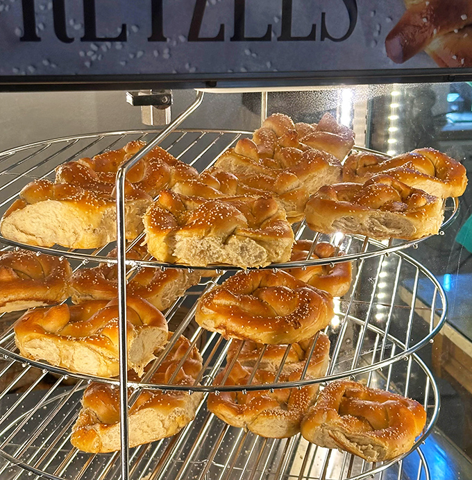Fresh pretzels cooling on the rack, their golden surfaces glistening with possibility. This is what carb dreams are made of, folks.