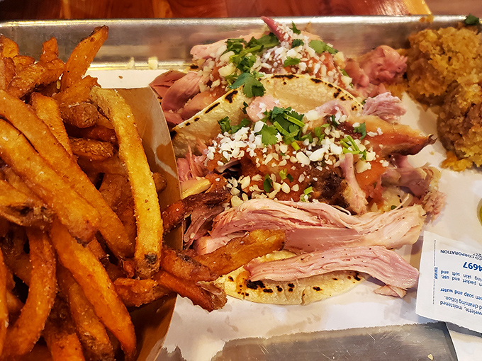 Pulled chicken tacos garnished with fresh herbs and crumbled cheese&mdash;proof that barbecue brilliance extends beyond the traditional sandwich format.