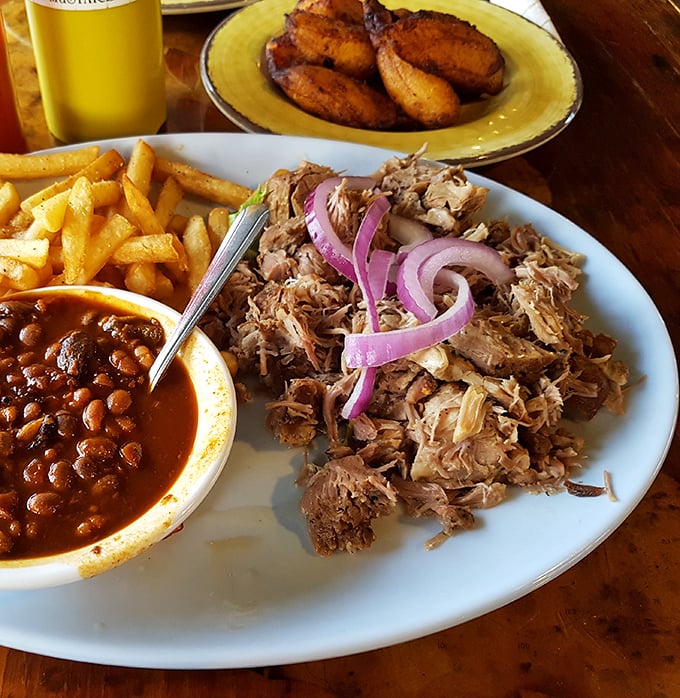Pulled pork so tender it practically surrenders to your fork, served with the kind of sides that remind you why comfort food earned its name.