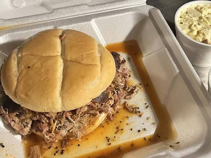 This isn't just a sandwich; it's an engineering marvel of smoke-kissed pulled pork piled so high you'll need to strategize your first bite.