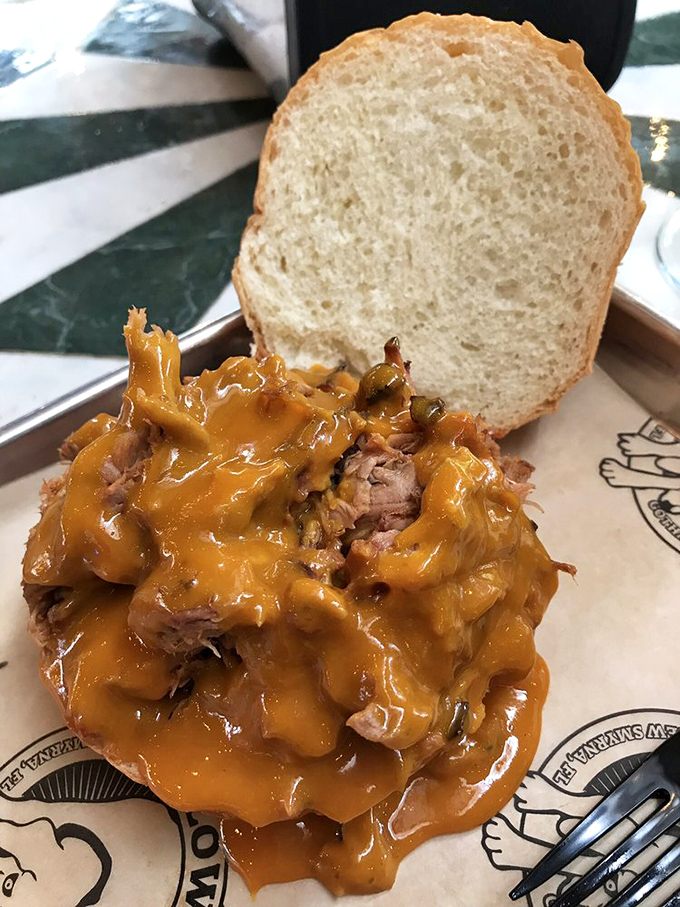 Pulled pork so tender it practically surrenders to gravity, crowned with a sauce that should be bottled and sold as liquid happiness.