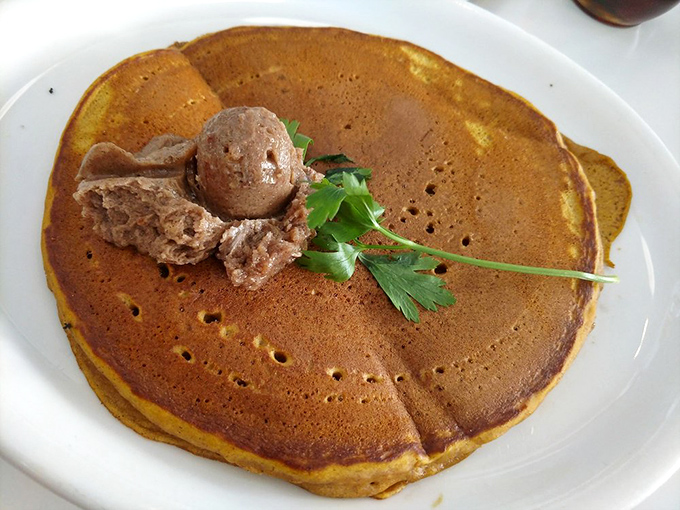 This pumpkin pancake isn't just breakfast&mdash;it's autumn on a plate, complete with a scoop of what appears to be cinnamon butter melting into pancake perfection.