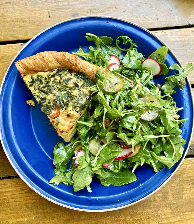 A slice of savory quiche with a side salad&mdash;proof that "eating your vegetables" can be the highlight of your day rather than a chore.