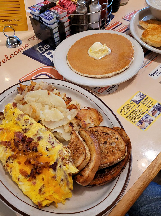 Breakfast perfection on a plate - a golden omelet, crispy home fries, and pancakes that could make a grown adult weep with joy.