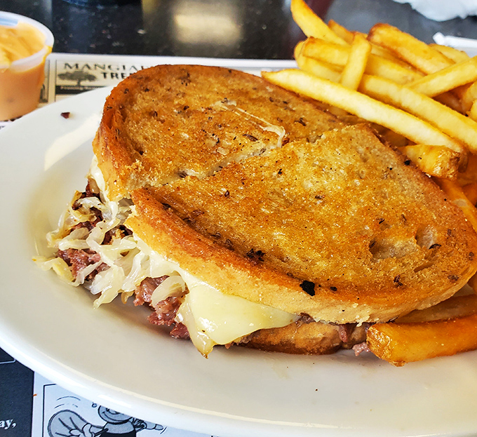 This isn't just a sandwich; it's architecture. Perfectly grilled bread supporting the delicate balance of sauerkraut, meat, and melted cheese&mdash;with fries standing guard.