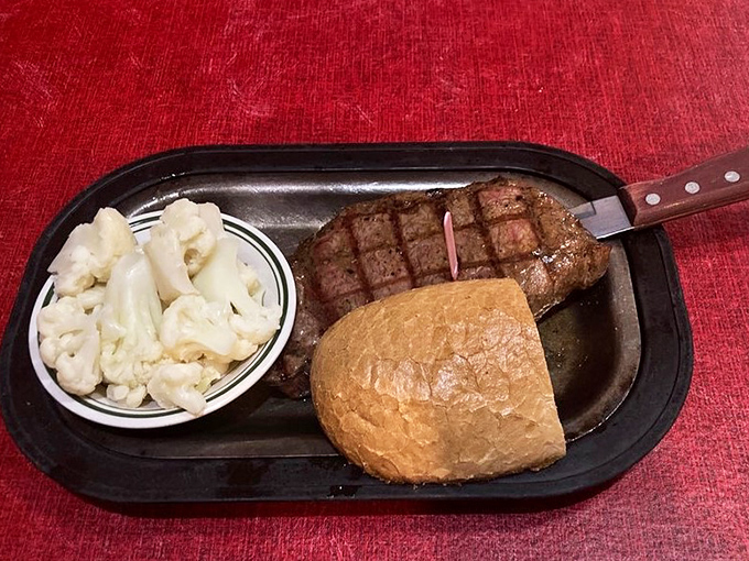 A perfectly grilled ribeye with cauliflower and roll &ndash; proof that happiness doesn't need to be complicated, just expertly prepared and served hot.