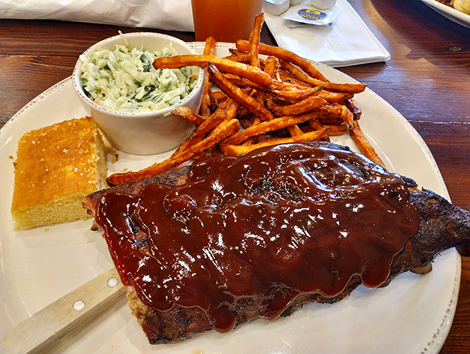 Ribs glistening with sauce that would make angels weep. The sweet potato fries and cornbread aren't sidekicks&mdash;they're essential supporting characters in this delicious drama.