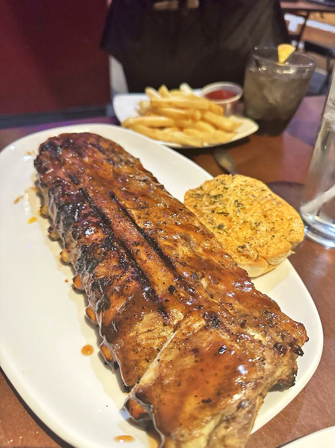 These ribs don't just fall off the bone – they practically leap into your mouth, leaving a trail of sticky, sweet BBQ evidence on your smiling face.