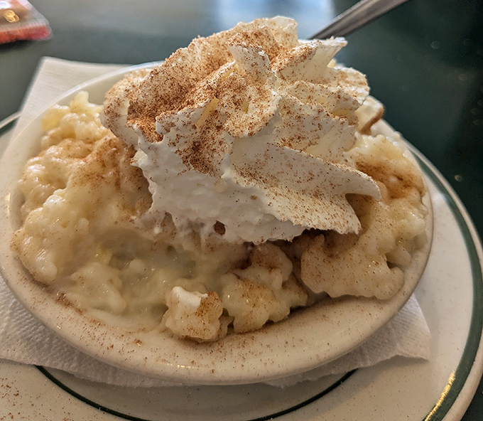 Rice pudding that would make your grandmother both jealous and proud, topped with a cloud of whipped cream and cinnamon whispers.