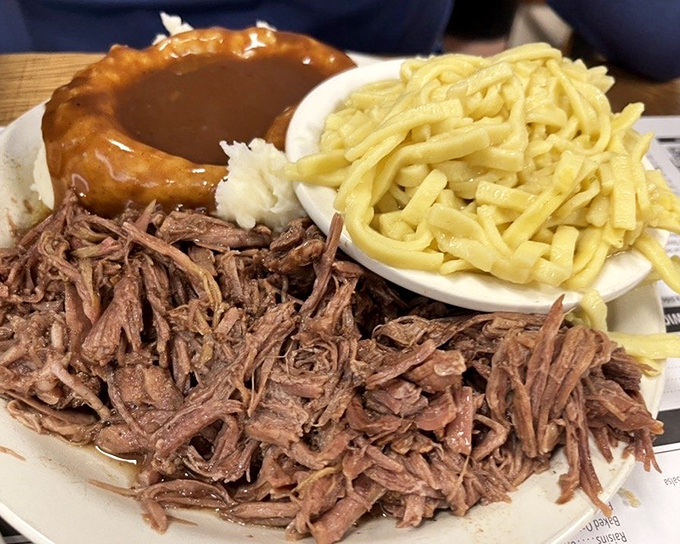 Behold the roast beef dinner: tender, shredded meat alongside buttery noodles and a gravy-filled Yorkshire pudding that defies gravity.