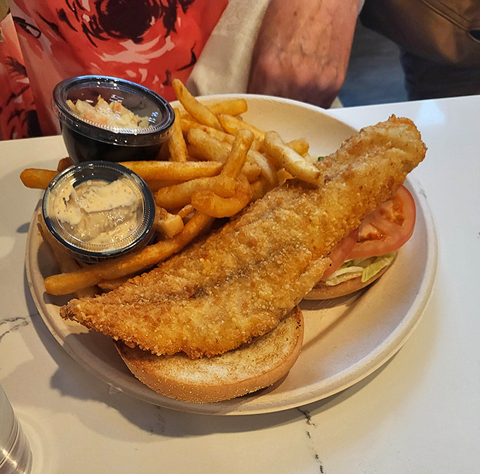 The rockfish sandwich&mdash;Maryland's answer to coastal cuisine&mdash;arrives golden and crispy, flanked by fries and house-made sauces that demand to be sampled.