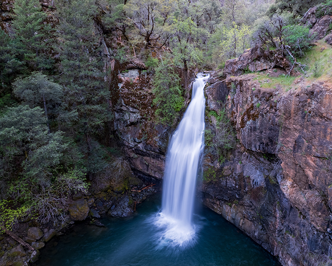 Mother Nature's own spa treatment. The falls cascade down rocky steps like they're late for an important appointment with the pool below.