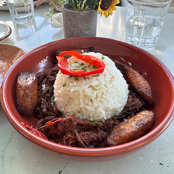 Ropa vieja so tender it practically falls apart when you look at it sideways, swimming in rich sauce.