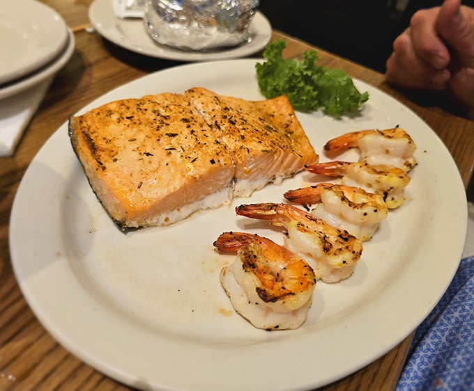 Salmon and shrimp sharing a plate like old friends at a high school reunion. The herb crust on that salmon deserves its own fan club.