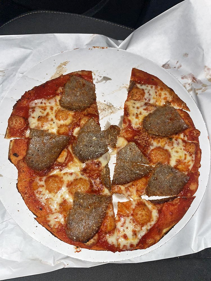 The sausage pizza showcases perfectly seasoned Italian sausage atop that signature thin, crispy crust. Comfort food that doesn't need to shout about its credentials.