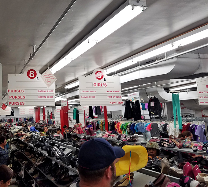 Section markers hover above the retail wilderness like trail signs, guiding intrepid bargain hunters through territories of purses, shoes, and "hot styles."