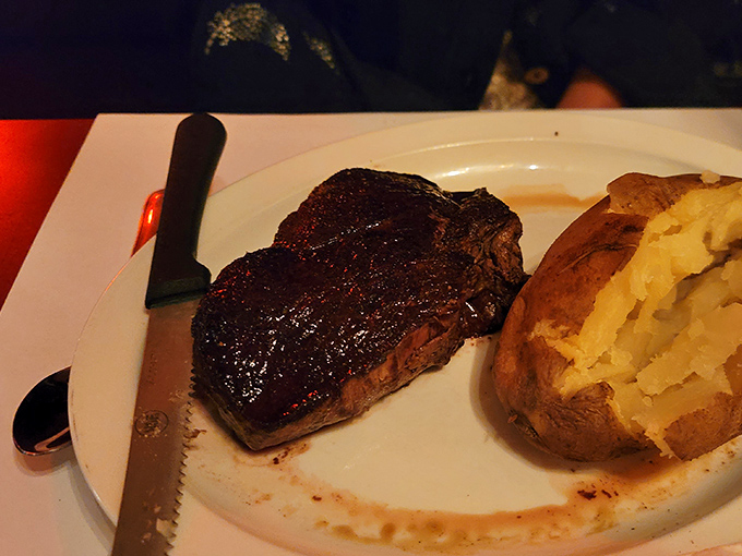 This sirloin steak delivers serious flavor punch alongside that fluffy baked potato begging for butter attention.