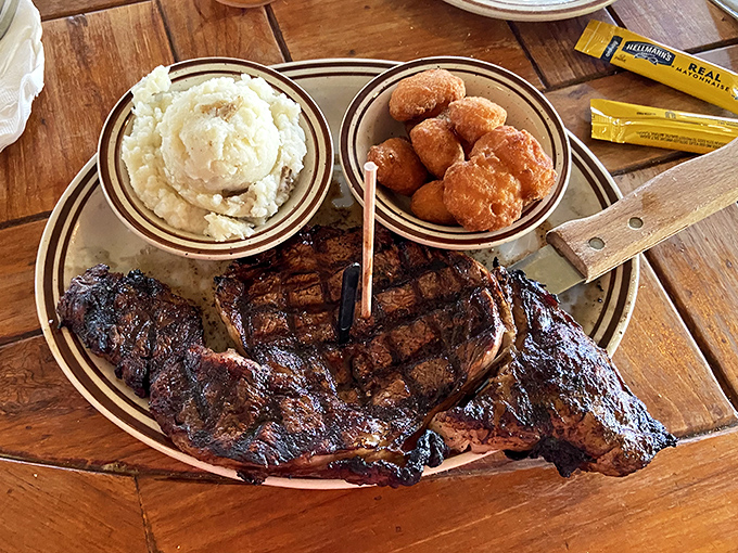 A perfectly grilled steak with that crosshatch pattern that says "someone in this kitchen really cares" &ndash; paired with hush puppies that could make a Louisianan homesick.