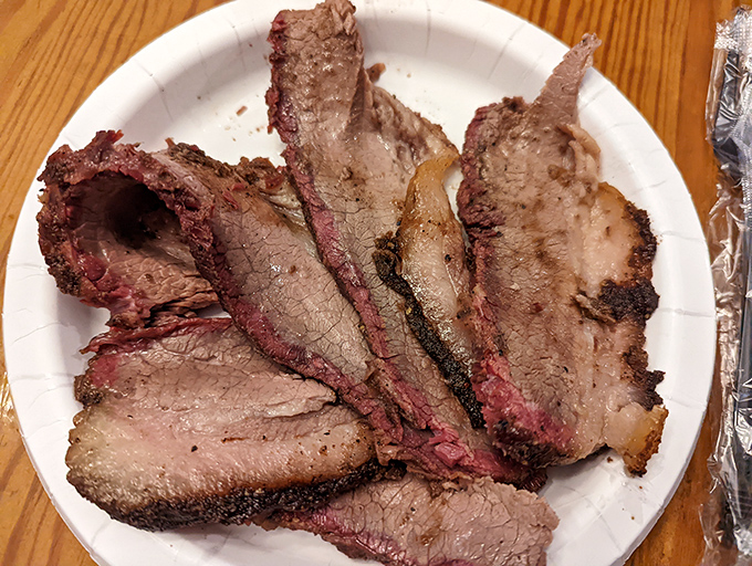 Behold the holy grail of barbecue: properly smoked brisket with that telltale pink smoke ring. This isn't just meat; it's a time-honored tradition wrapped in foil.