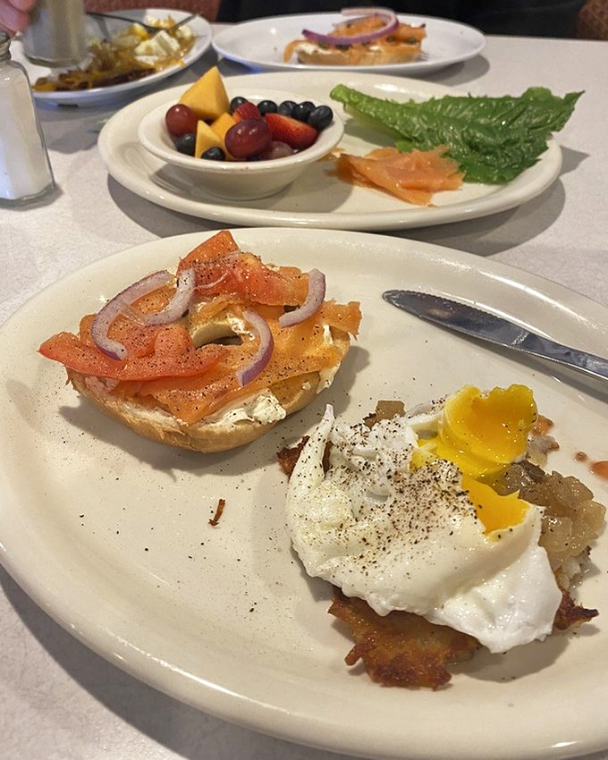 The Smoked Salmon Breakfast arrives like a deconstructed New York deli experience on a Florida vacation. That perfectly poached egg is living its best life.