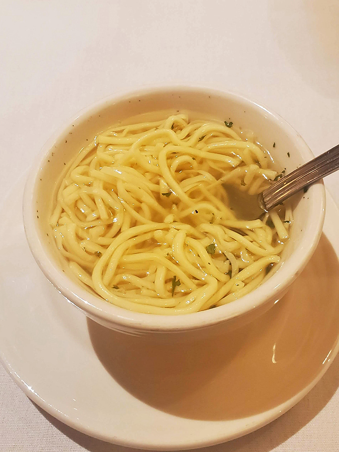 This isn't just chicken noodle soup; it's liquid comfort in a bowl, with noodles that somehow maintain their dignity despite the hot bath.