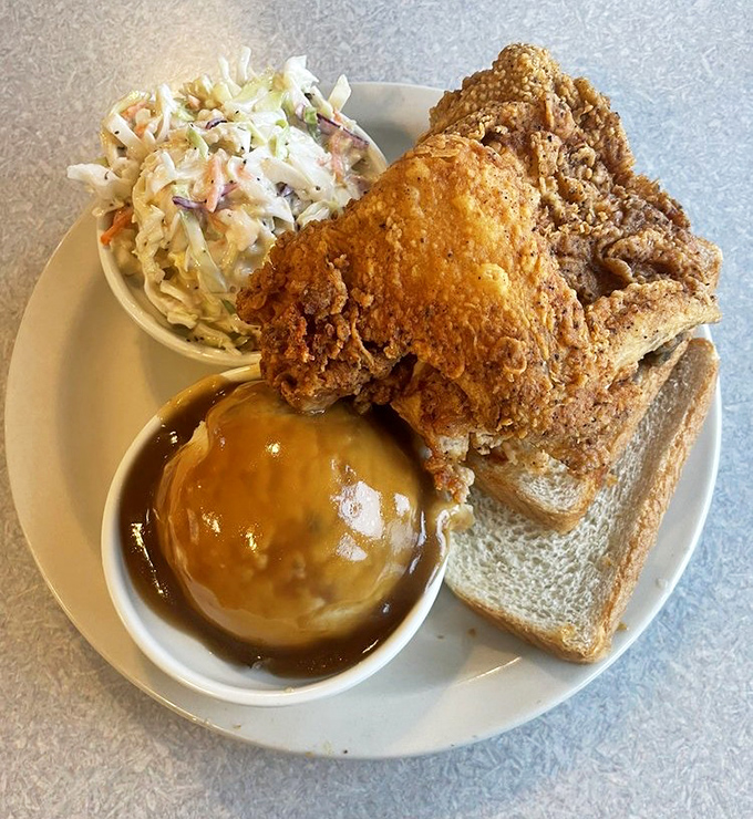 Golden-fried chicken that crackles with each bite, paired with creamy mashed potatoes and tangy coleslaw&mdash;a holy trinity of comfort.