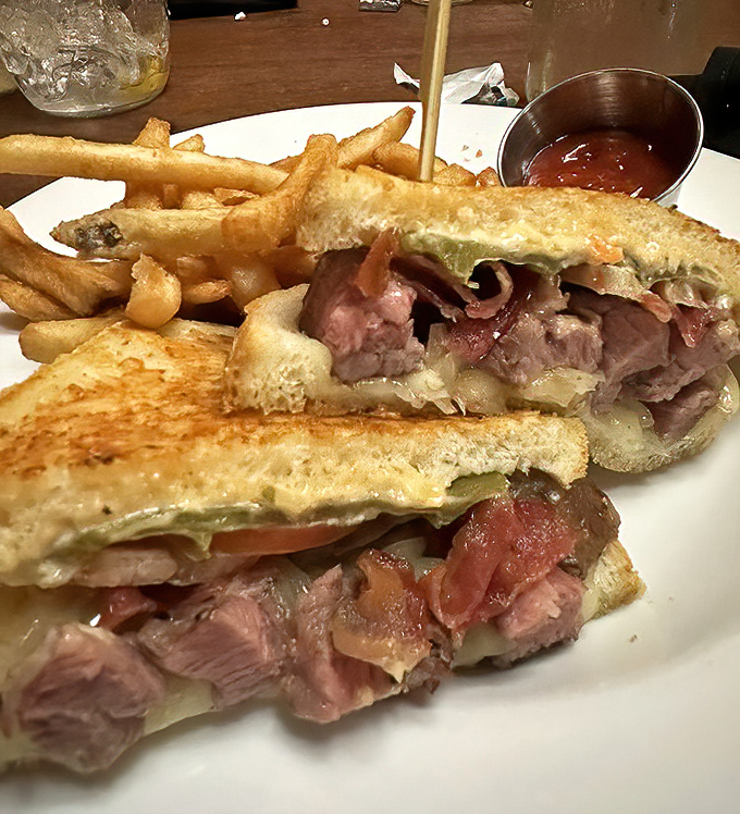 Not just any steak sandwich&mdash;this is architecture you can eat, where each layer contributes to a symphony of flavors that demands both hands and napkins.