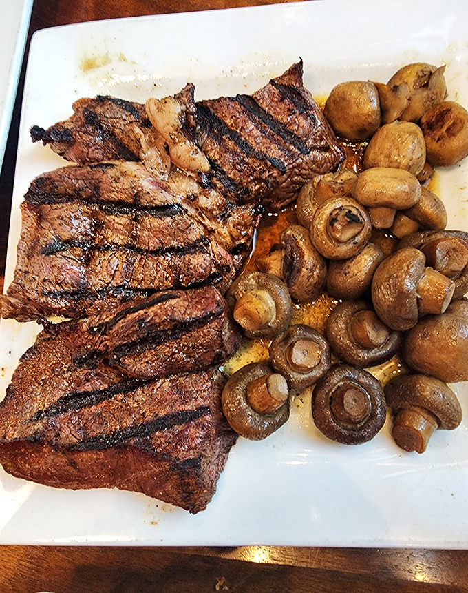 A perfectly grilled steak with those coveted grill marks, accompanied by saut&eacute;ed mushrooms&mdash;proof that sometimes the simplest combinations are the most divine.