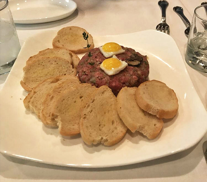 Steak tartare presented with military precision&mdash;raw beef never looked so civilized, topped with tiny sunny-side up quail eggs like culinary jewelry.