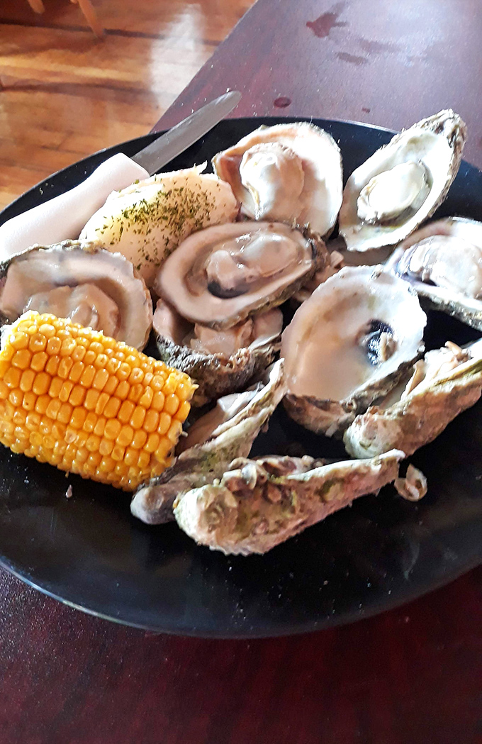 Plump, glistening oysters served with a side of corn&mdash;proof that sometimes the simplest presentations let truly fresh seafood shine brightest.