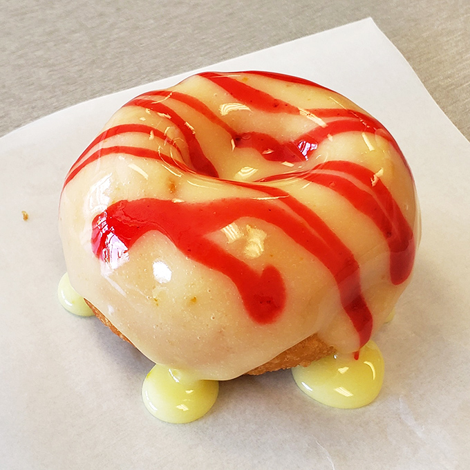 The strawberry cheesecake donut wears its red drizzle like a runway model, knowing full well it's too gorgeous to ignore.