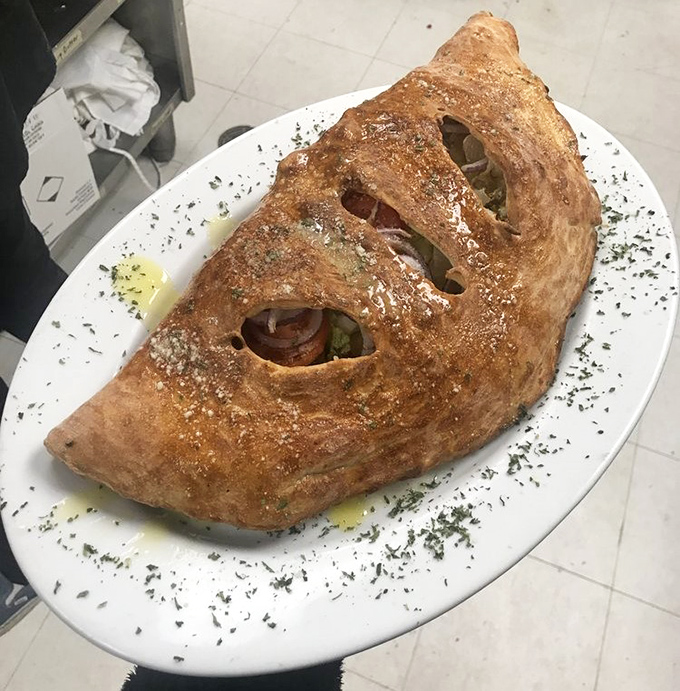 Not all heroes wear capes; some come in the form of this magnificent stromboli, a golden-crusted pocket of joy that feeds both stomach and soul.